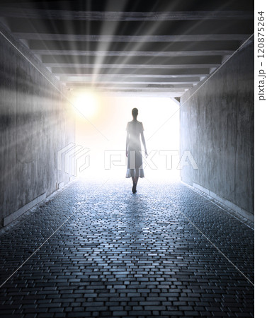 A woman emerges from a tunnel into the lightの写真素材 [120875264] - PIXTA