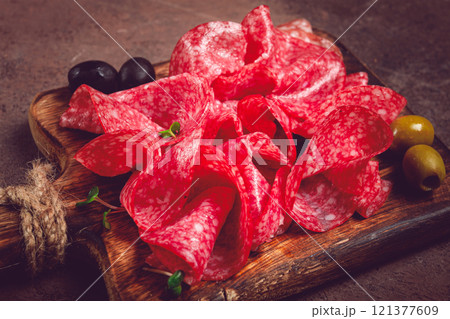 sliced salami sausage, on a wooden chopping...の写真素材 [121377609] - PIXTA