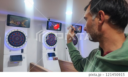 A man aims a dart at a darts machine. Concept...の写真素材 [121450915] - PIXTA