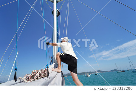 Male captain climbing mast of sailboat to check...の写真素材 [123332290] - PIXTA