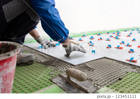 Tiler at work installing new floor with tiles....の写真素材 [123451111] - PIXTA