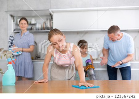 Teenage girl wiping table while cleaning house...の写真素材 [123567242] - PIXTA