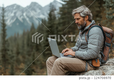 Man during hike sitting on a rock with a laptop...のイラスト素材 [124708970 ...