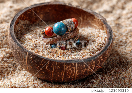 Bohemian jewelry in coconut bowl on sandy beachのイラスト素材 [125093310] - PIXTA