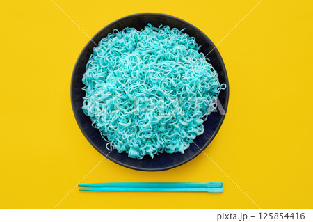 Bright blue noodles with chopsticks on yellow...の写真素材 [125854416] - PIXTA