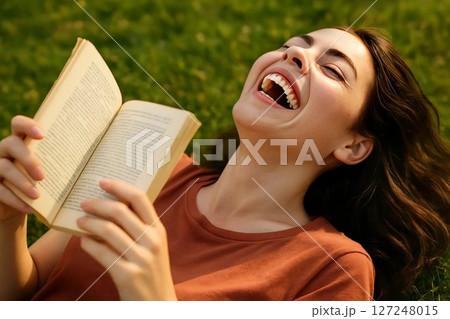 Joyful Girl Laughing Face-Up While Reading a Bookのイラスト素材 [127248015 ...