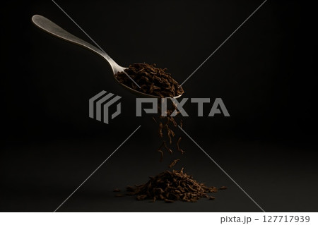 tilted spoon dropping loose black tea leaves in...のイラスト素材 [127717939 ...