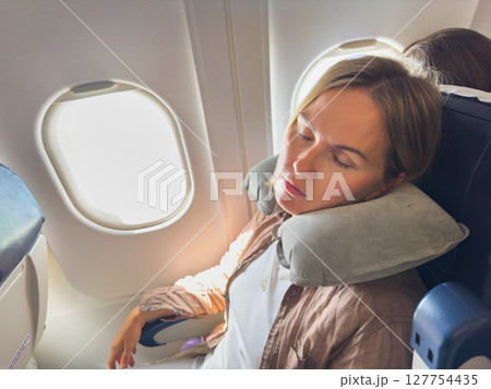 Rest on plane. Young woman napping sitting by...の写真素材 [127754435] - PIXTA