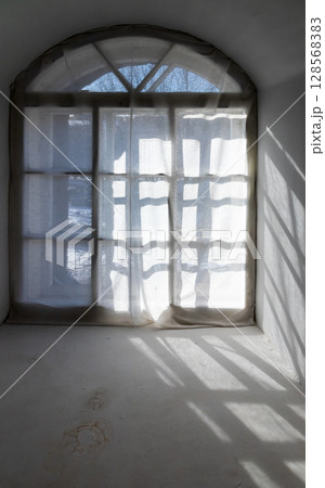 A softly lit window with sheer curtains and sun...の写真素材 [128568383] - PIXTA