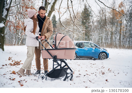 With pram. Happy couple having a walk in winter...の写真素材 [130178100] - PIXTA