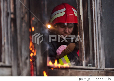 Firefighter rescuing a baby from burning...の写真素材 [133354219] - PIXTA