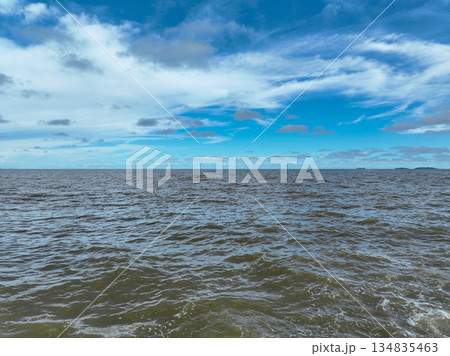 A wide ocean view with bright sky and drifting...の写真素材 [134835463] - PIXTA
