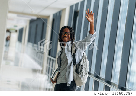 Bye hand gesture, smiling. Student with...の写真素材 [135601787] - PIXTA